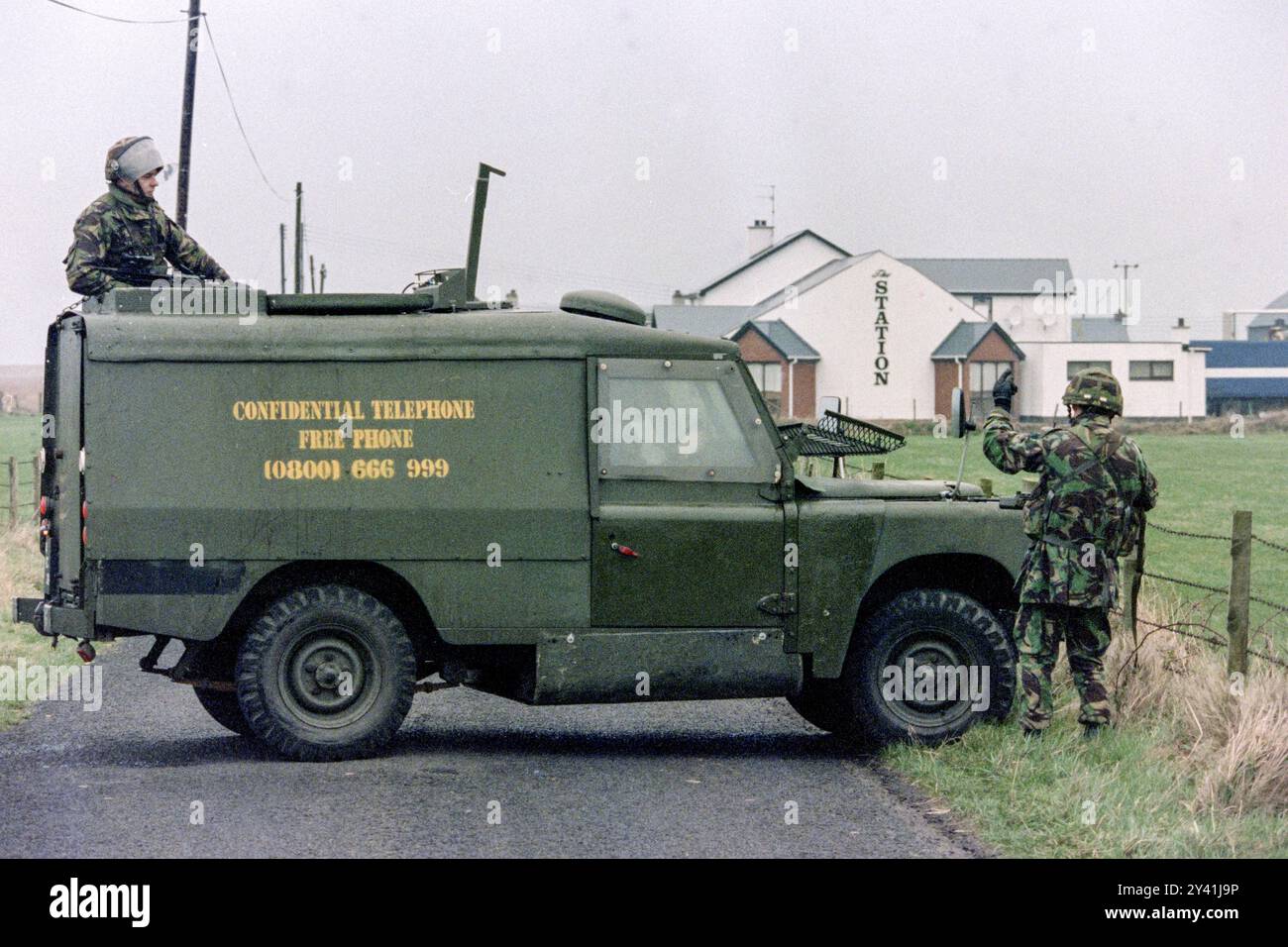 British soldiers use an armored Land Rover to secure a road checking ...