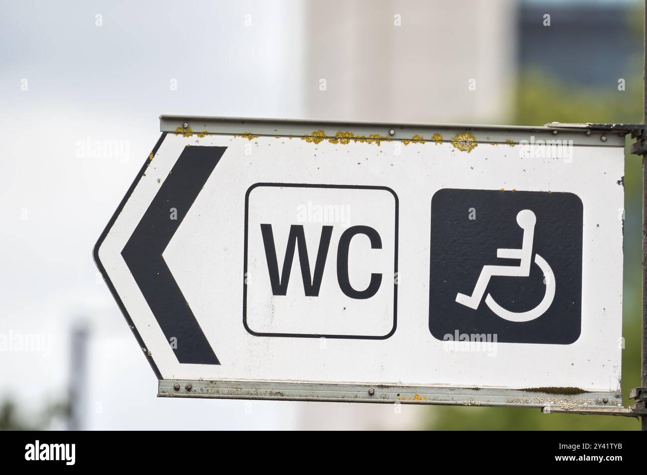 A directional sign indicating the location of restrooms, featuring ...