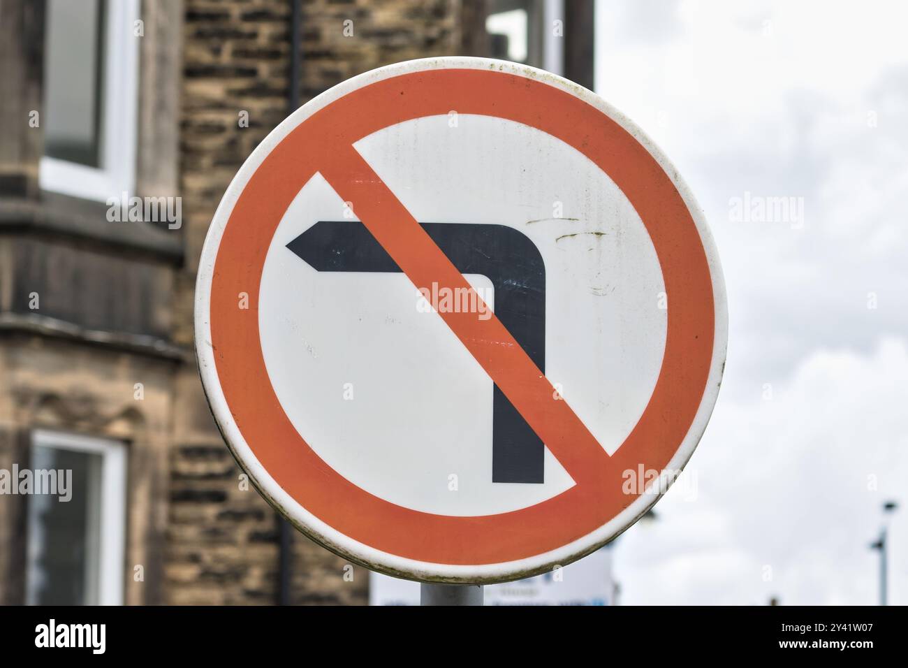 A circular traffic sign with a red border and a black arrow pointing ...