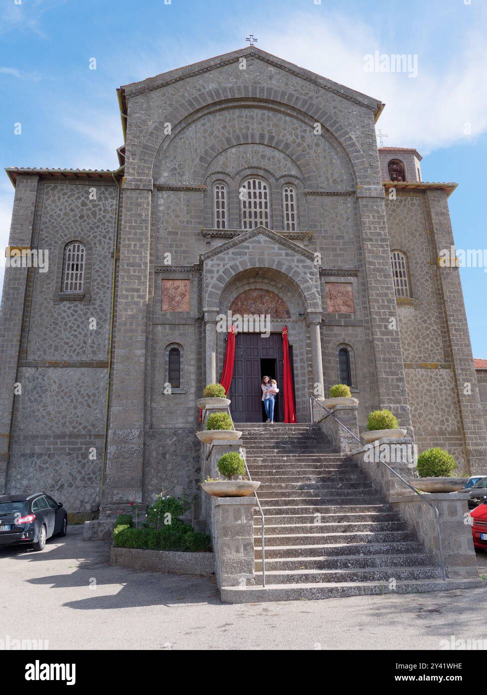 Lady holds a small child on the steps of Church of Corpus Christi in ...