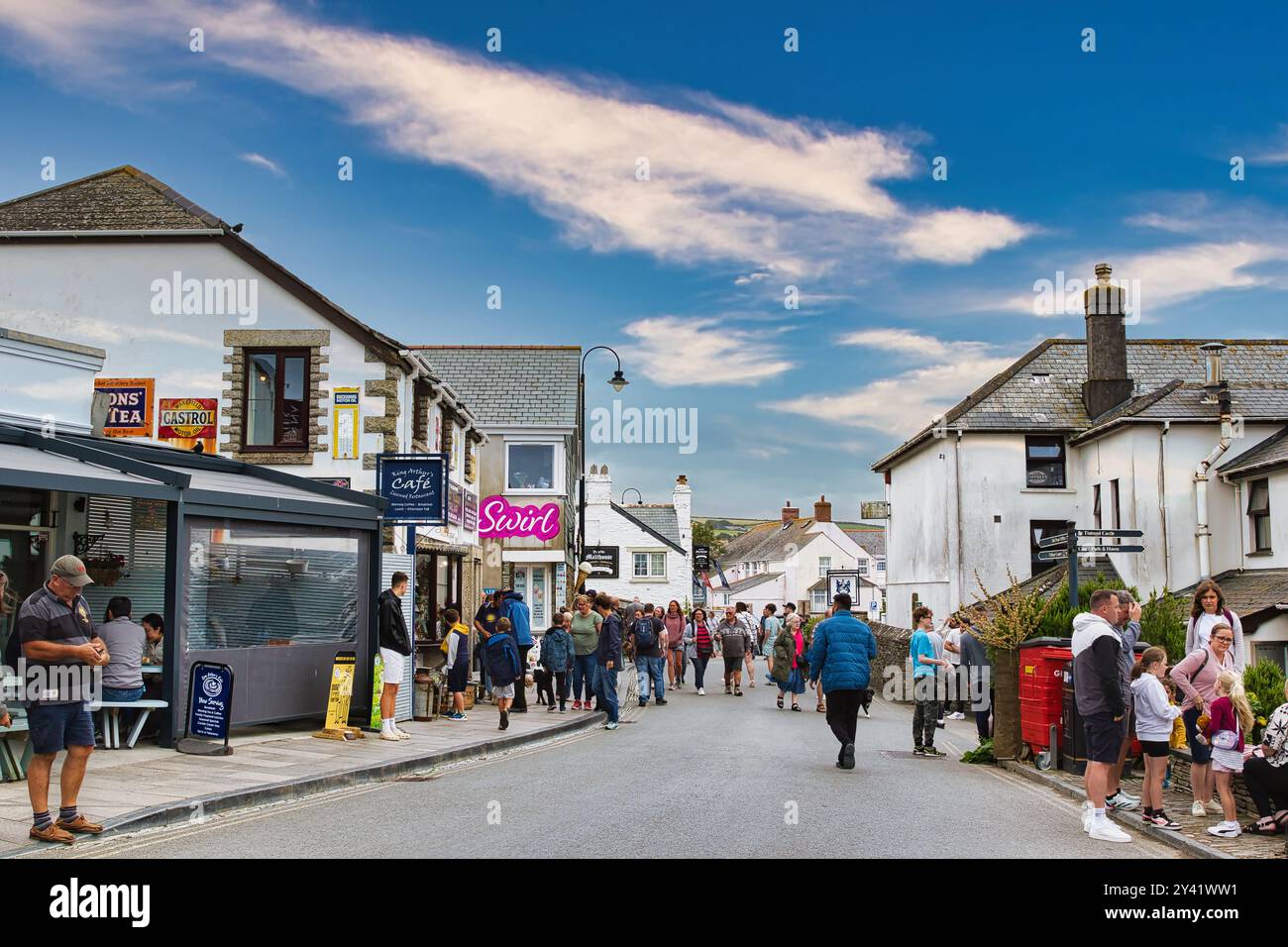 A busy street scene in a quaint town with people walking, shops lining ...