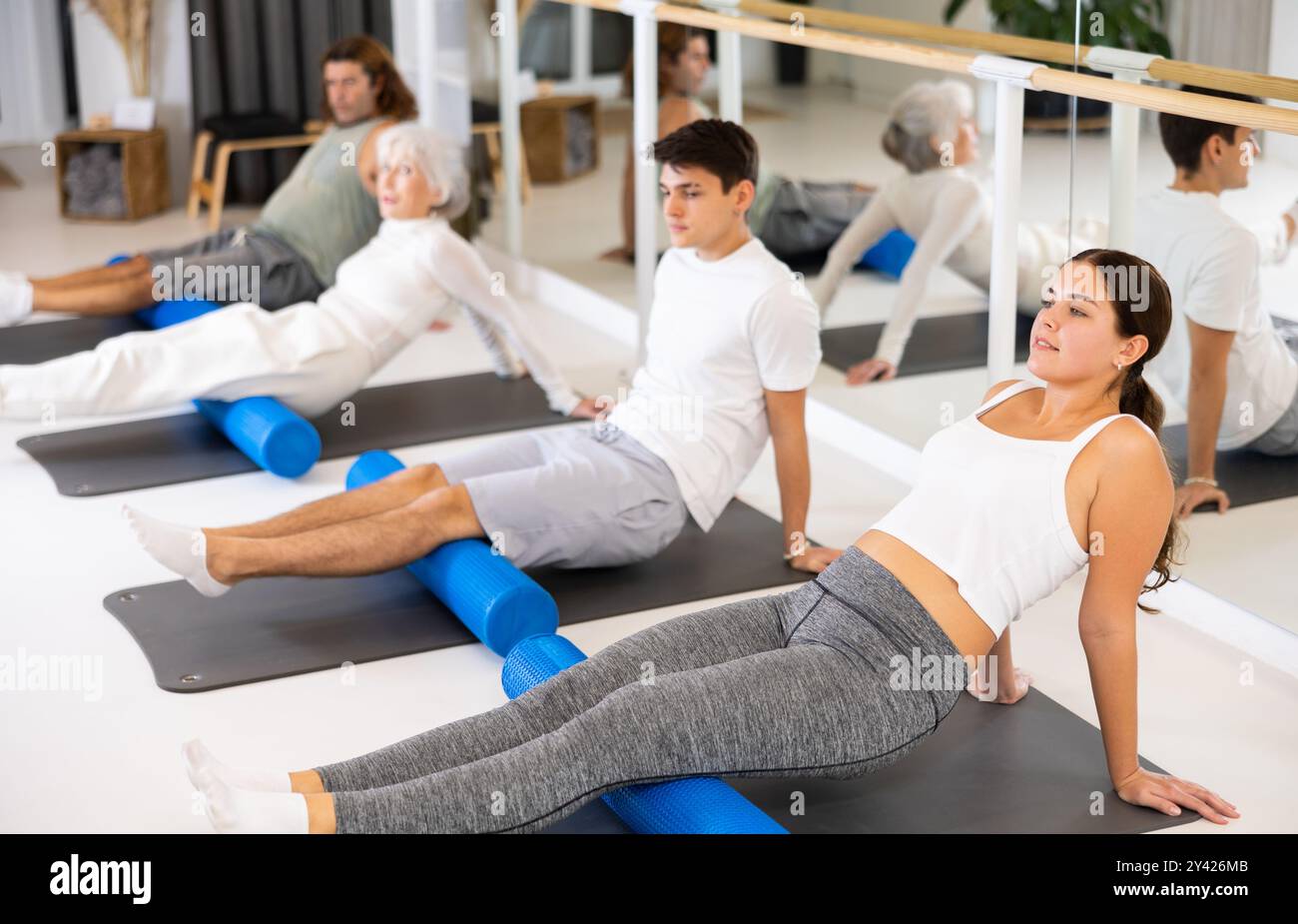 Group of different people doing exercises with roller Stock Photo - Alamy