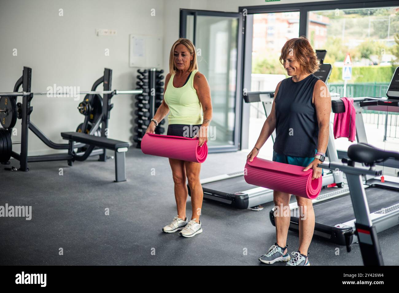 Two older women, dressed in sportswear, are getting ready to lay their ...