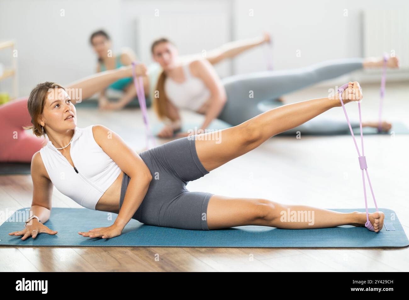 Girls perform exercises lying on side with legs straightened and narrow ...