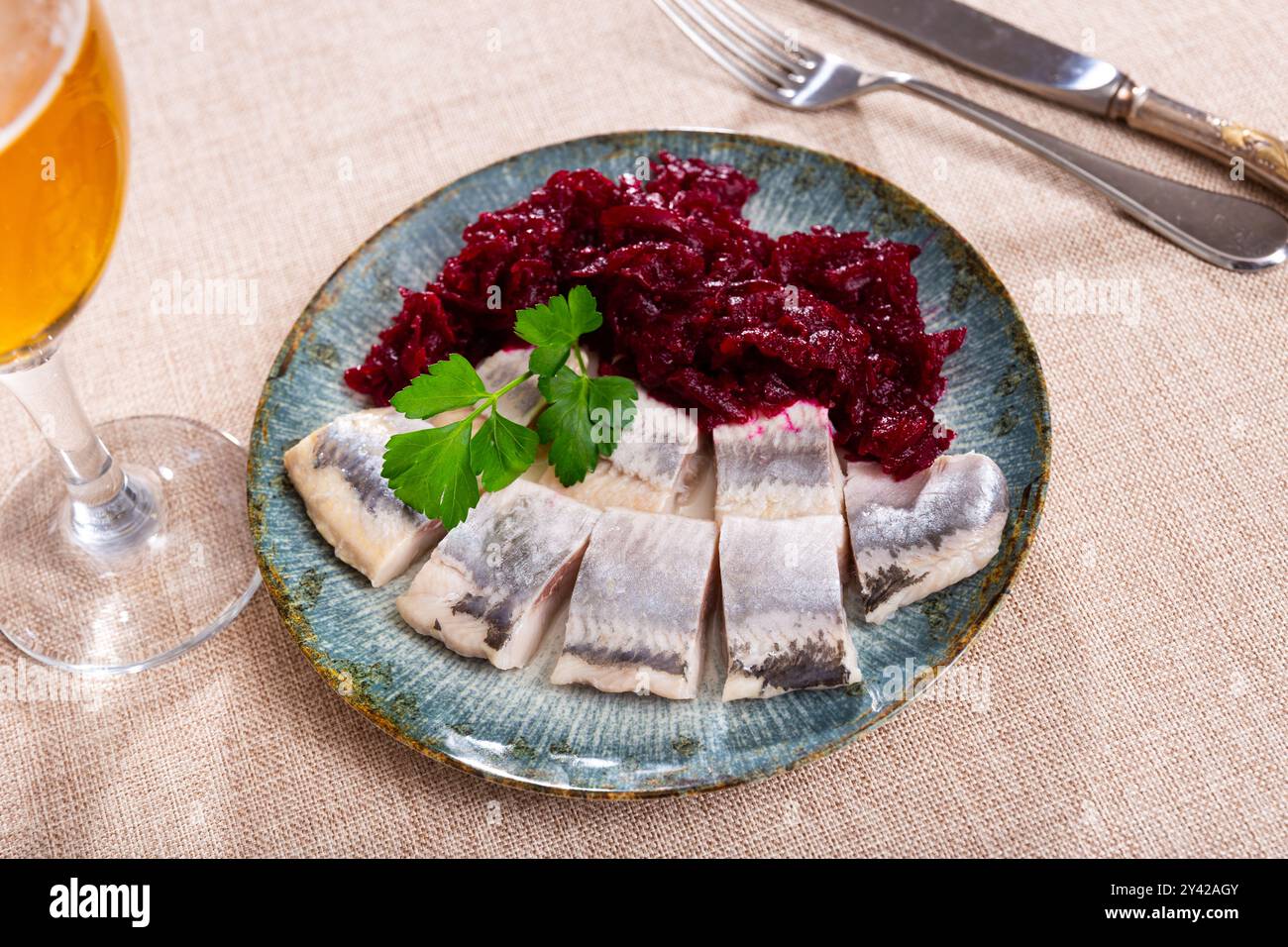 On round blue plate - lightly salted herring fillet cut into pieces ...