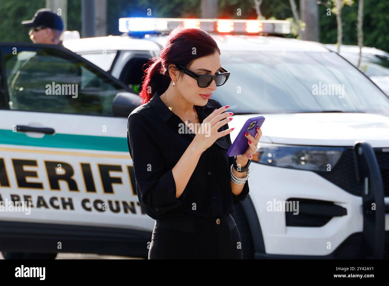 Laura Loomer uses her cell phone near Trump International Golf Club ...