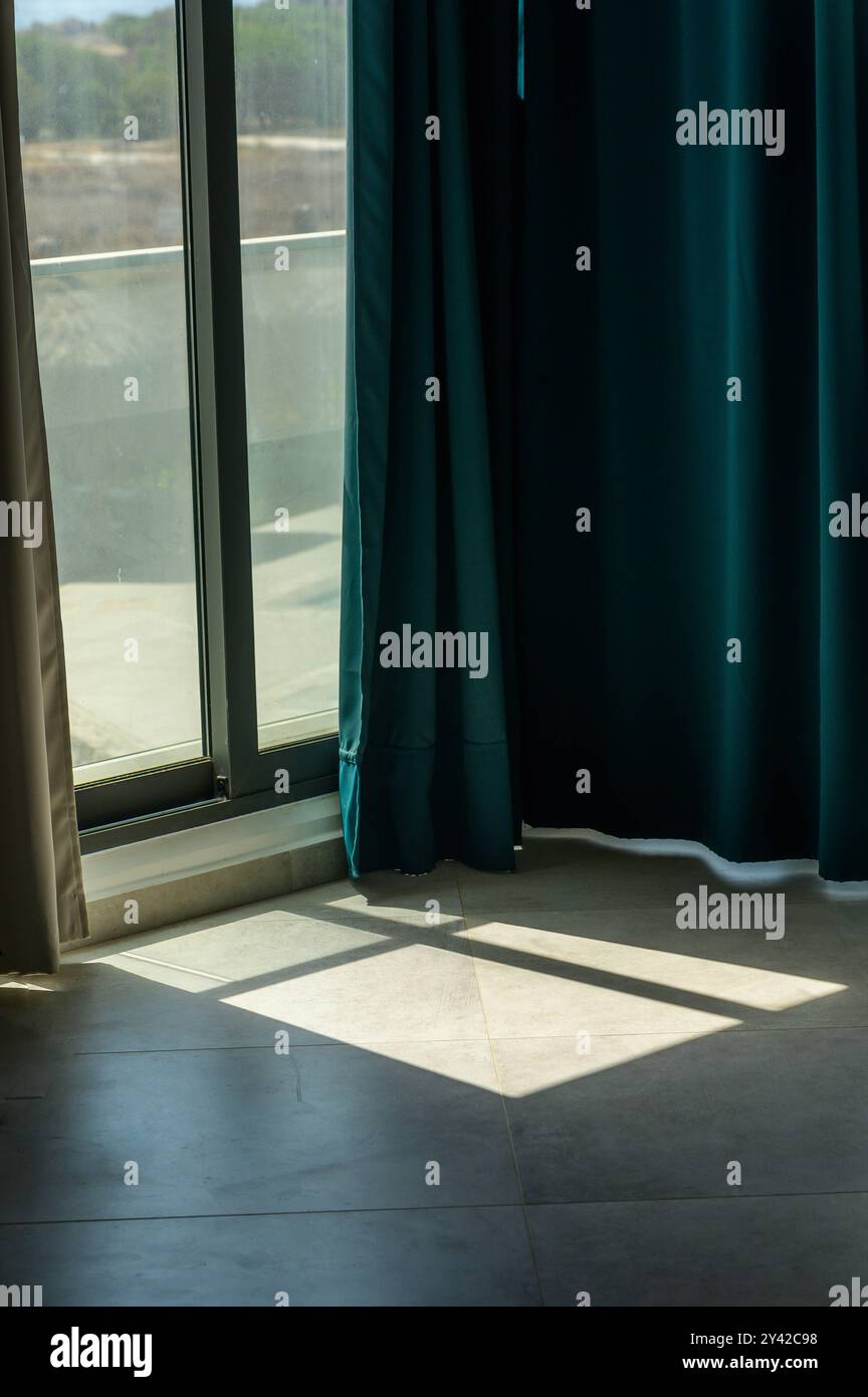 Sunlight pours through panoramic window in modern empty living room of ...