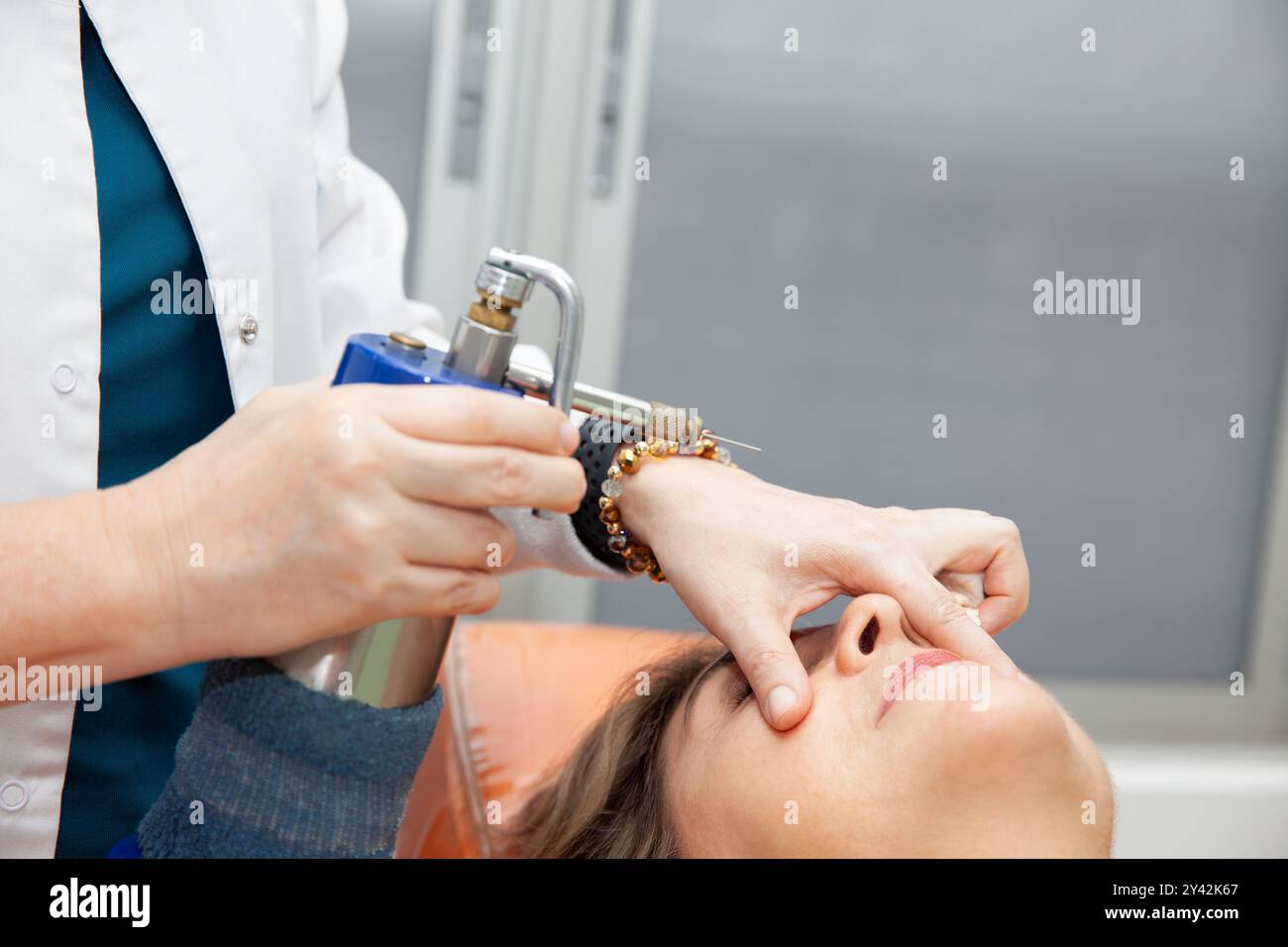 Dermatologist applying cryotherapy for skin lesions on a senior female ...