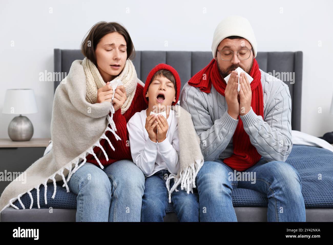 Cold symptom. Family suffering from fever on bed at home Stock Photo ...
