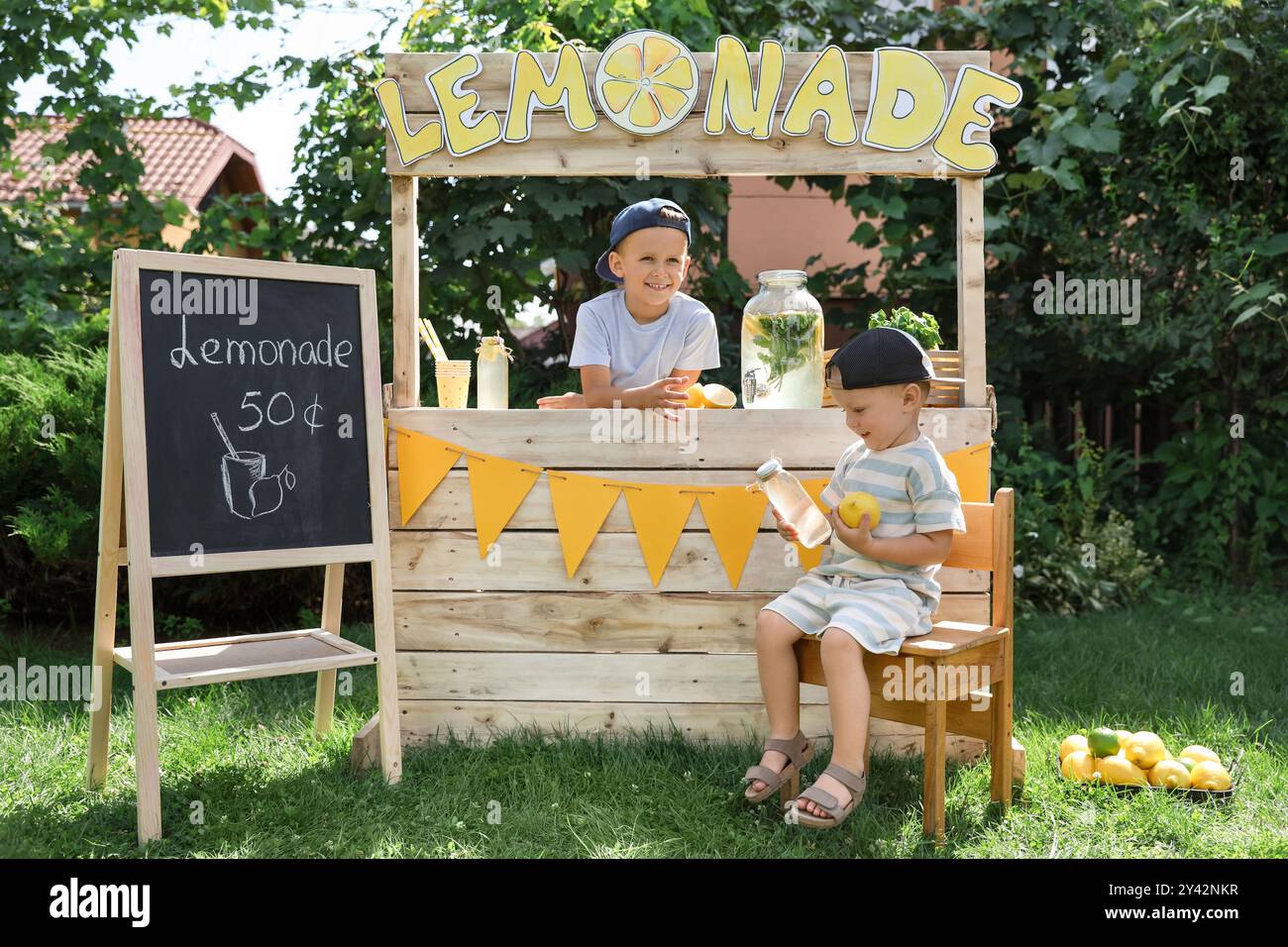 Cute boys near lemonade stand in park Stock Photo - Alamy