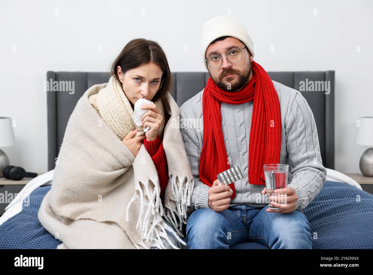 Cold symptom. Couple suffering from fever on bed at home Stock Photo ...