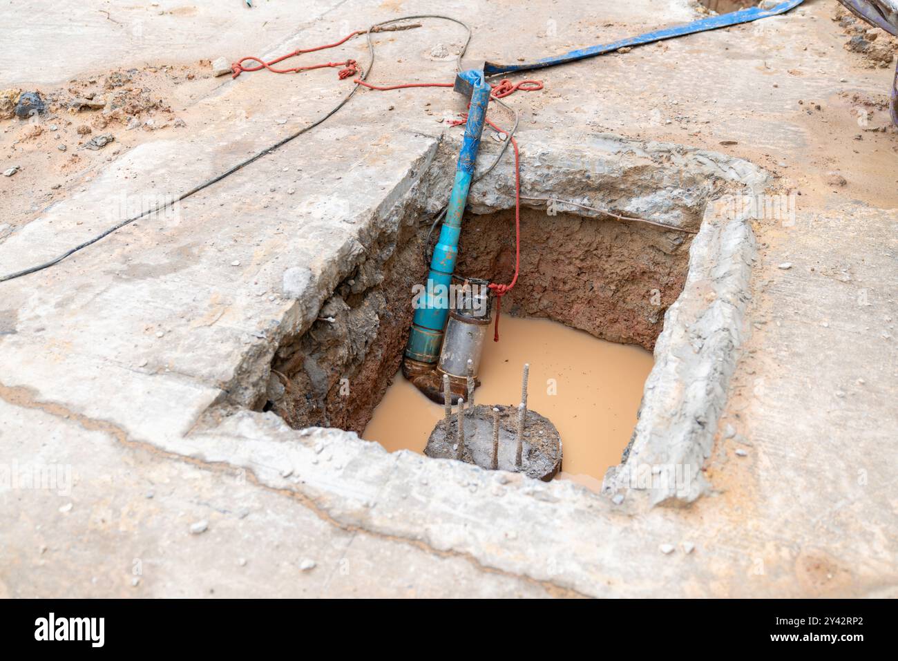 Submersible pump suck water out of pit for pour concrete foundation in ...