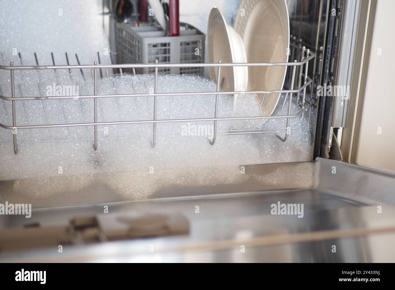 A Dishwasher Overflowing with Suds and Sparkling Clean Plates Ready for ...