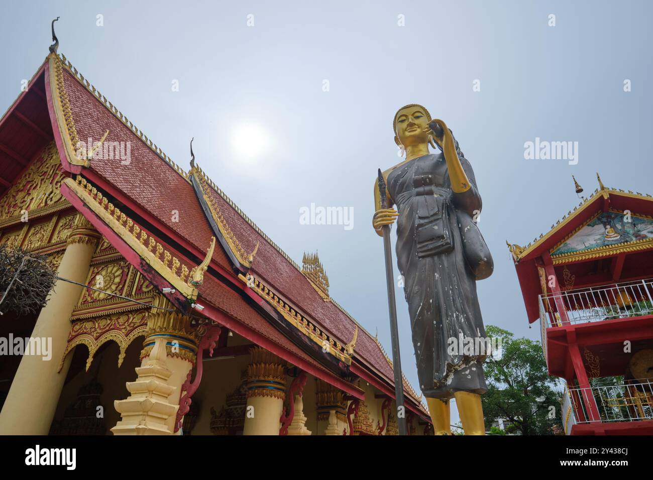 Exterior view with standing Buddha statue with a walking cane, staff at ...
