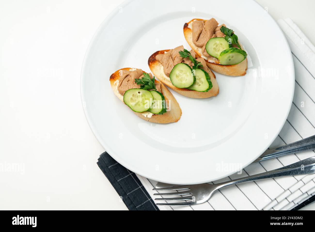 Savory canapes topped with creamy spread and cucumber slices served on ...