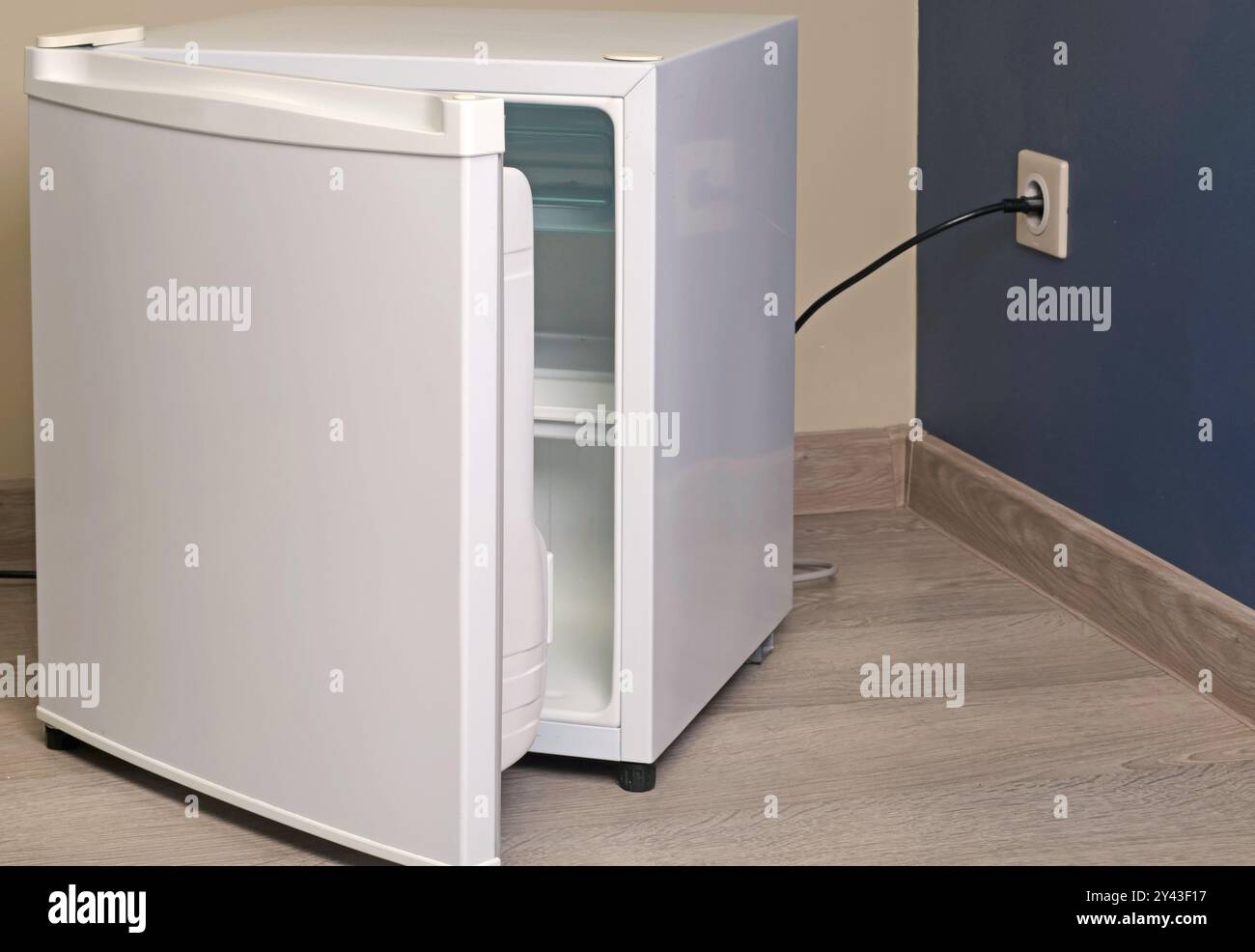 Single chamber empty white open mini fridge with freezer above on floor ...