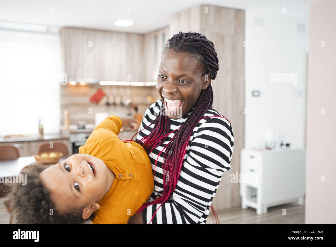 Joyful multiracial family playing together in a modern kitchen Stock ...