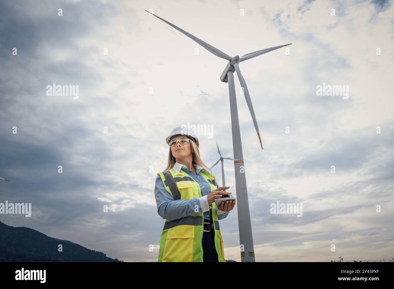 A female engineer is working with a wind turbine model in a renewable ...