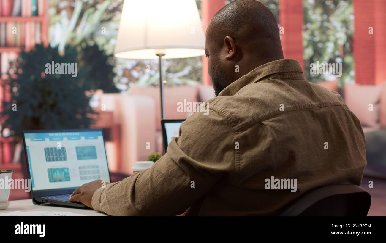 Startup entrepreneur looking into project details on laptop at his home ...