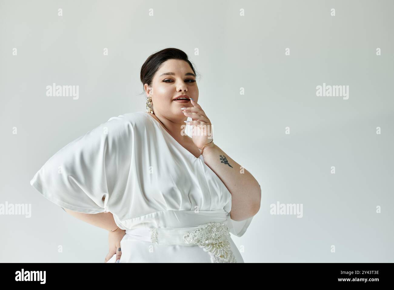 A stunning plus size bride showcases her elegance with a white wedding ...