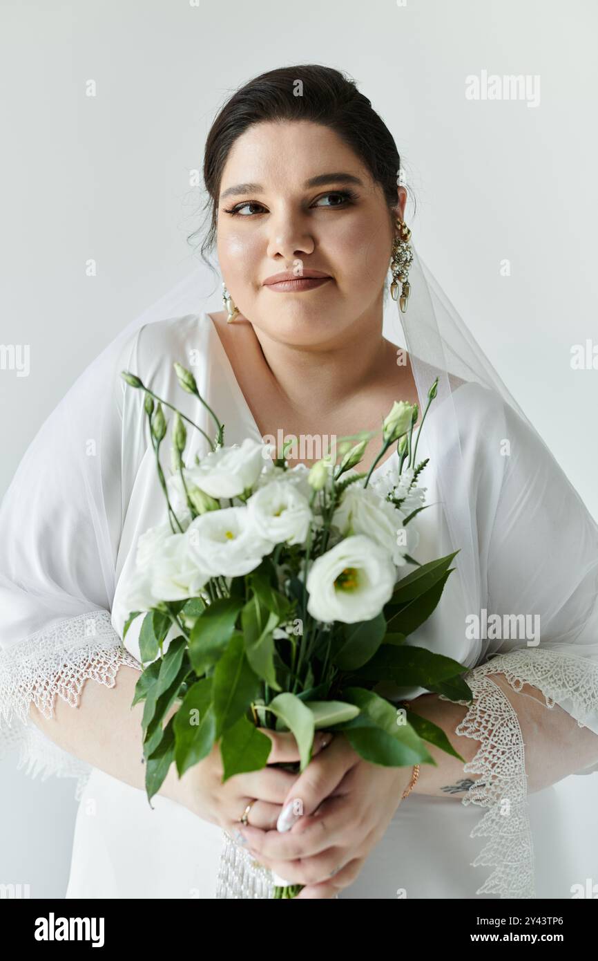 A beautiful plus-size bride embraces her bouquet, exuding elegance and ...