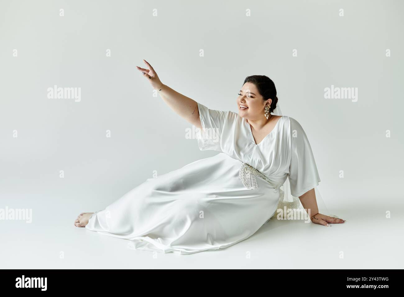 A stunning bride beams while seated in her beautiful gown, exuding joy ...