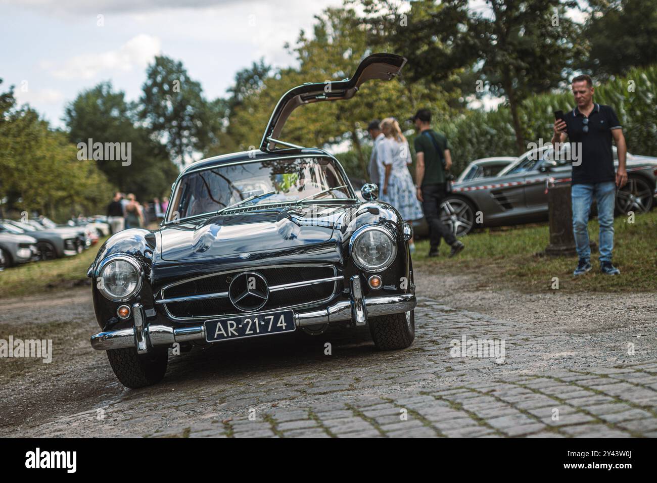 Black Mercedes-Benz 300SL Gullwing on display at a car event, with ...