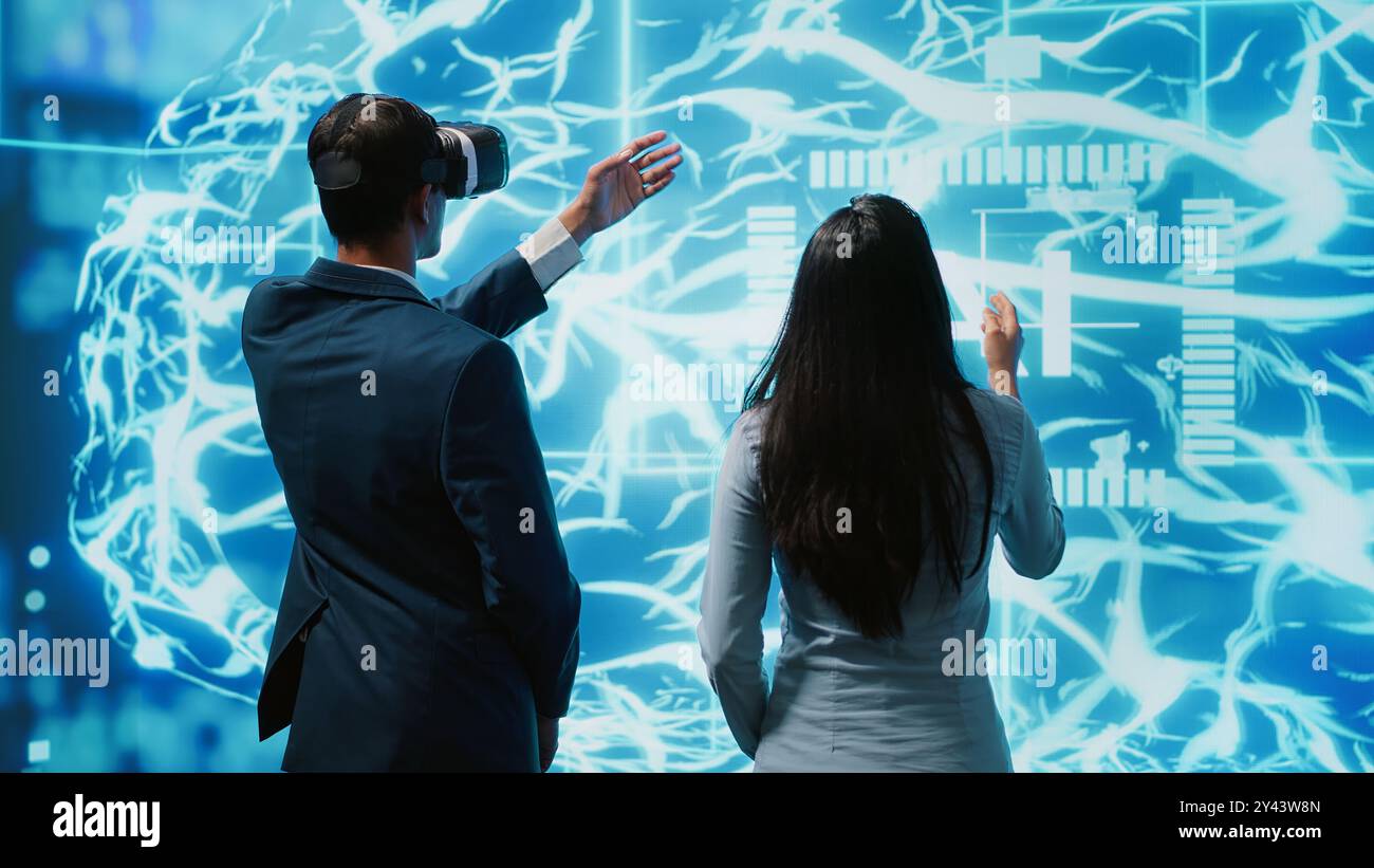 Engineer wearing VR headset looking at hologram of artificial ...