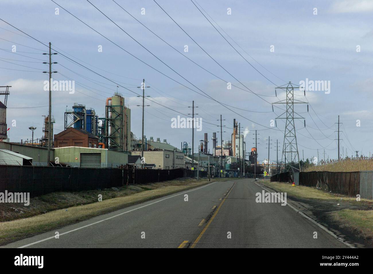 A road leading to a steel mill under high voltage power cables Stock ...