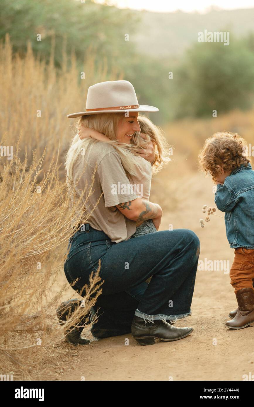 A mom and two children hug on a trail Stock Photo - Alamy