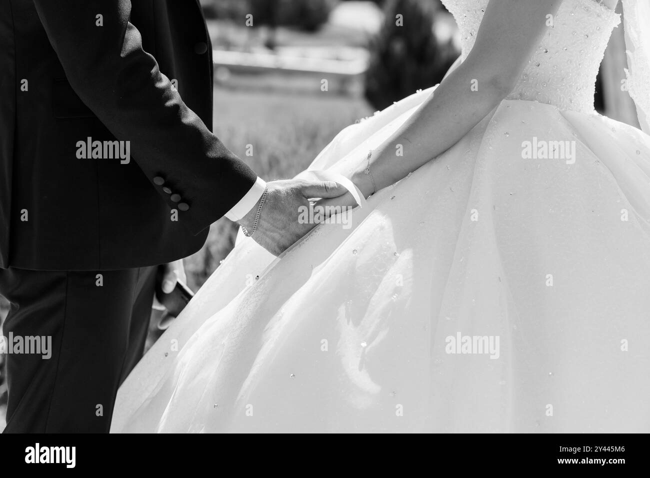 Romantic Black and White Close-Up of Bride and Groom Holding Hands on ...