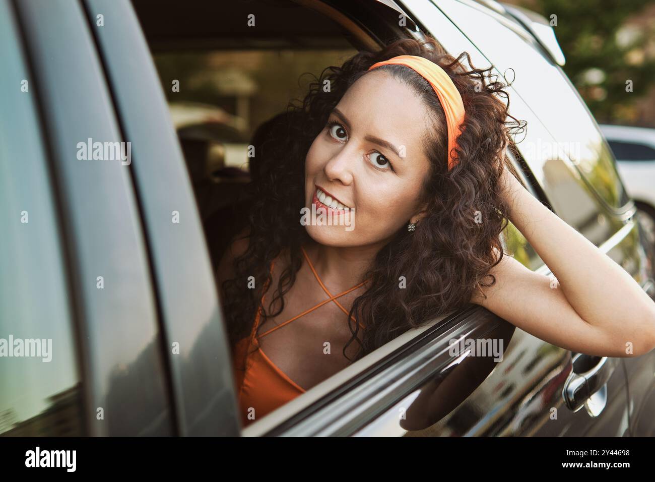 Young woman smiling from car window on a sunny day Stock Photo - Alamy