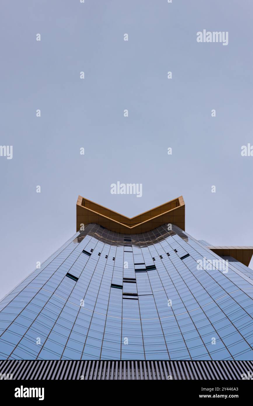Skyscraper captured from below with reflective glass and sharp angles ...