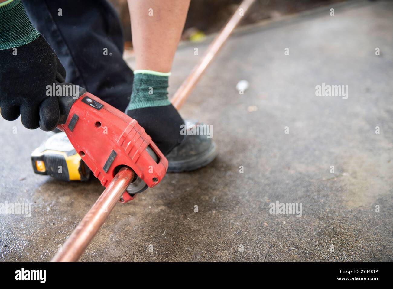 Plumber using cordless pipe cutting tool on copper tubing Stock Photo ...