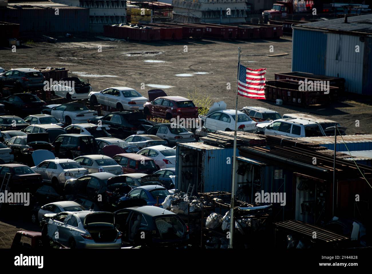 Tattered American Flag flies over a dark auto salvage junk yard Stock ...