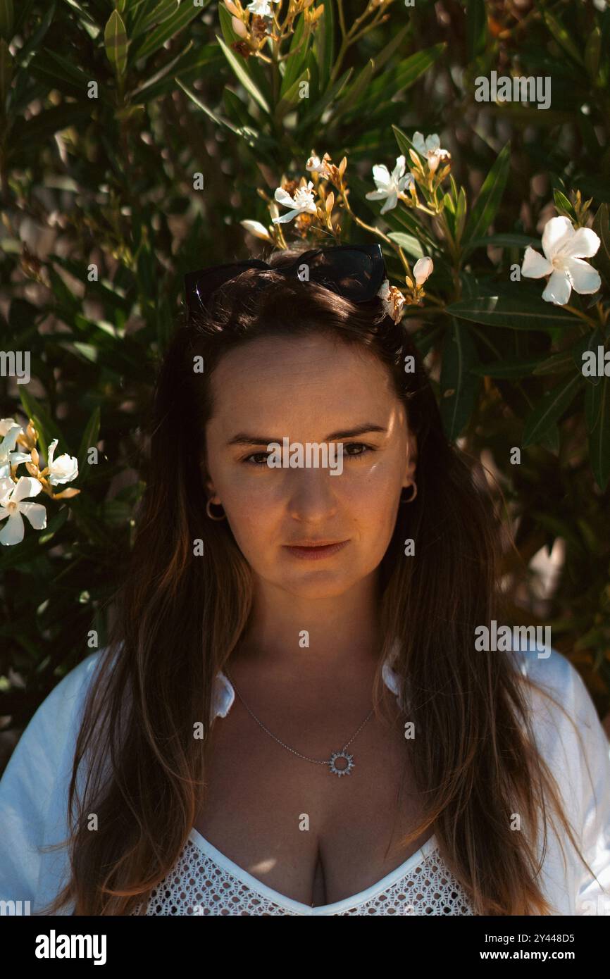 Portrait young woman standing by flowering bush Stock Photo - Alamy