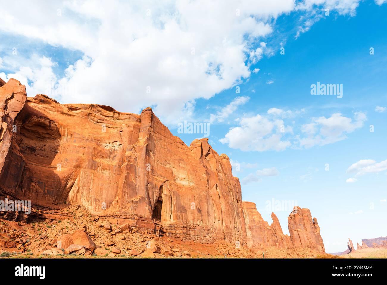 Sunlit sandstone cliffs with a bright blue sky in Monument Valley Stock ...