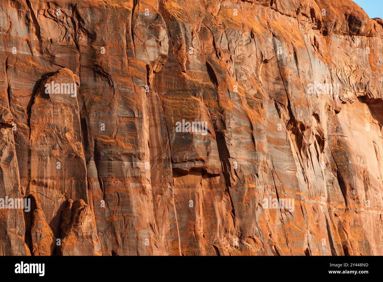 Eroded red sandstone rock face with striations in Monument Valley Stock ...