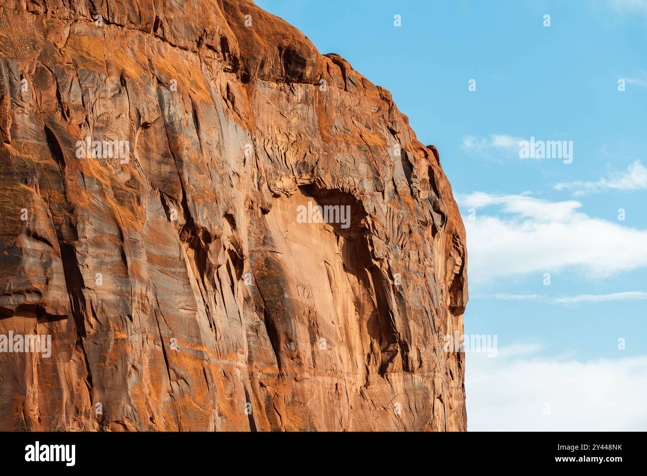 Sunlit sandstone rock face with erosion patterns in Monument Valley ...