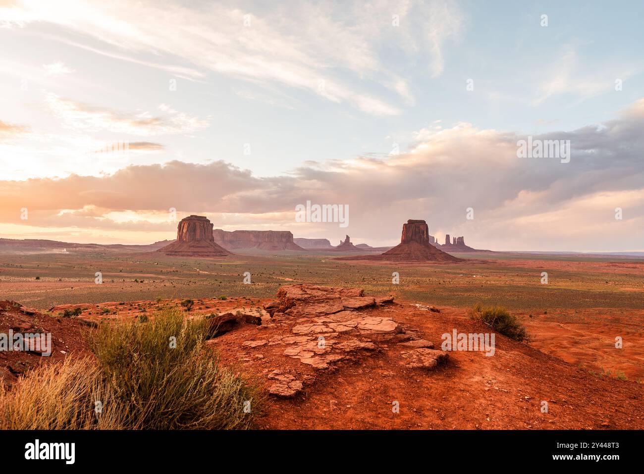 Monument Valley's sandstone buttes glowing under a soft sunset sky ...