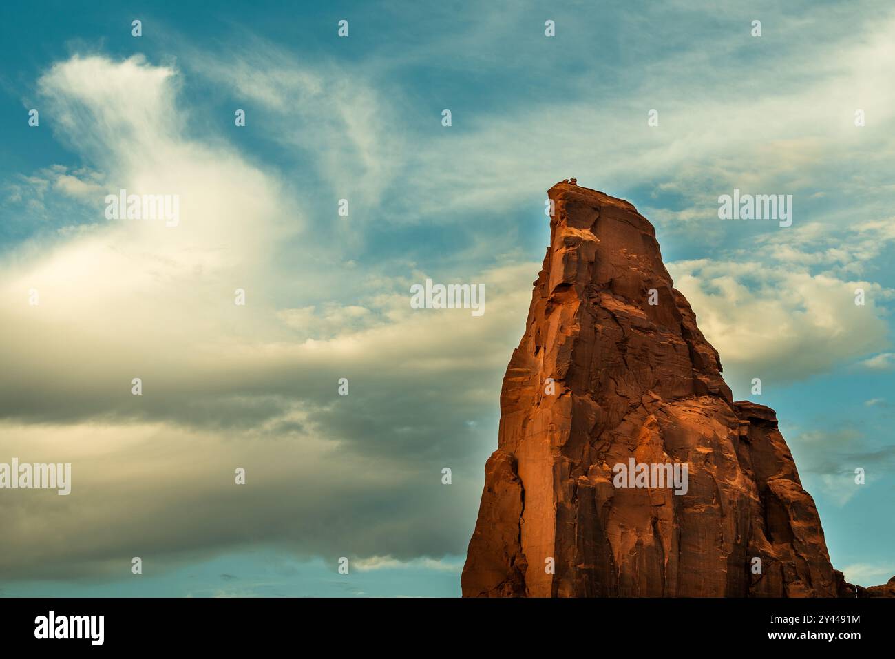 Tall rock spire against vibrant blue sky in Monument Valley Stock Photo ...