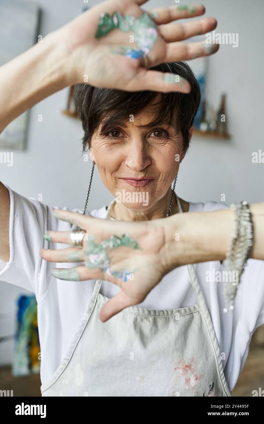 A passionate artist engages in painting with colorful hands in her ...