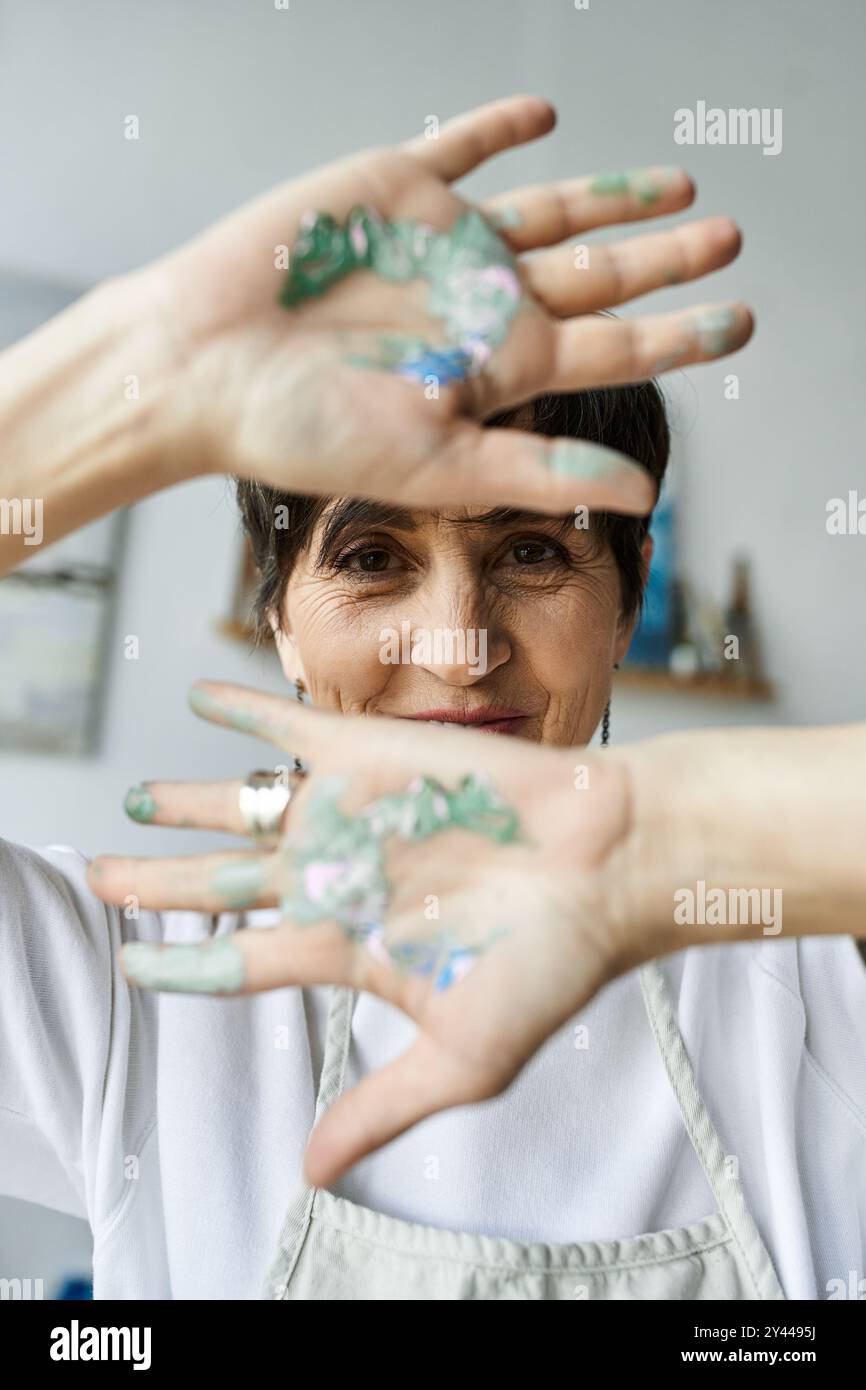 An artist reveals her paint splattered hands, celebrating her creative ...