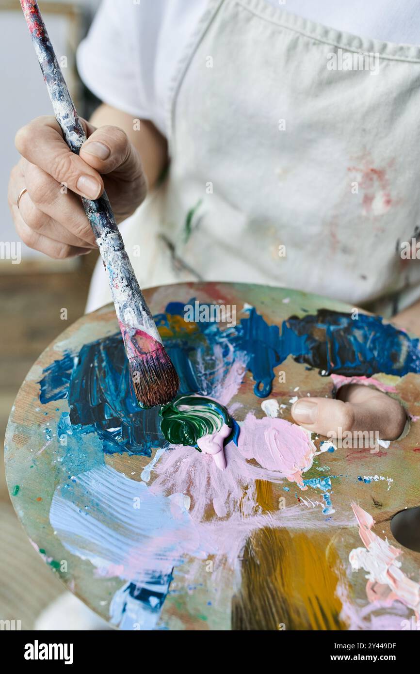 An artist blends colors on her palette, immersed in creation in her ...