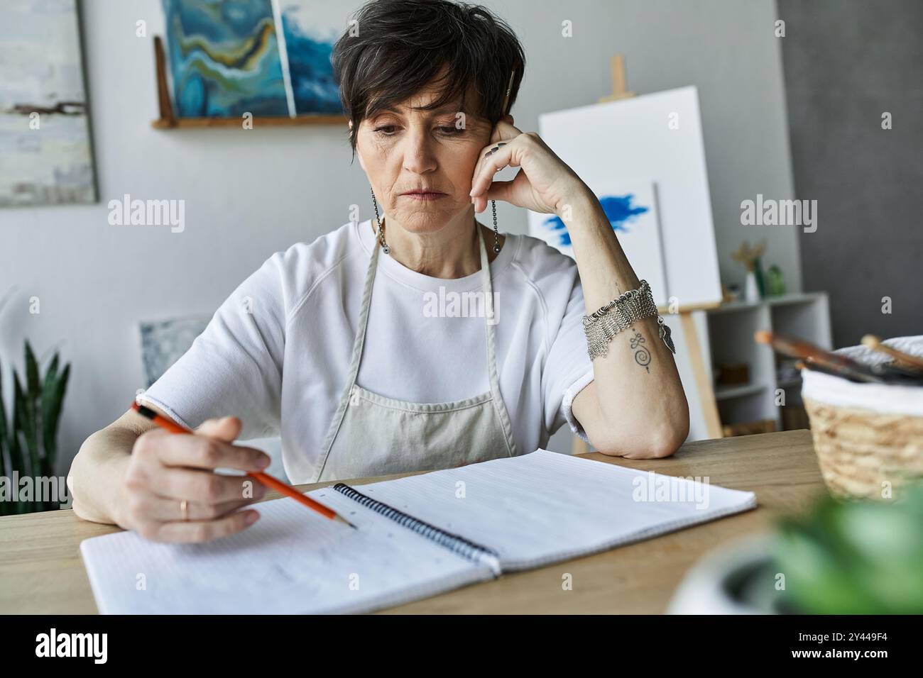 A focused artist sketches ideas in her serene art studio Stock Photo ...