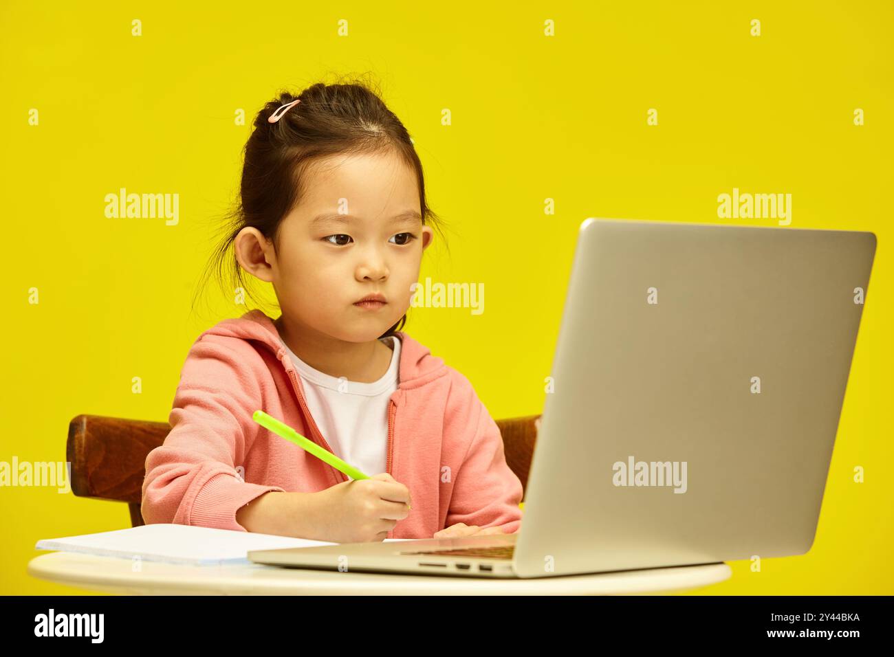 Studious Asian first grader Girl Concentrates on Distance Learning ...