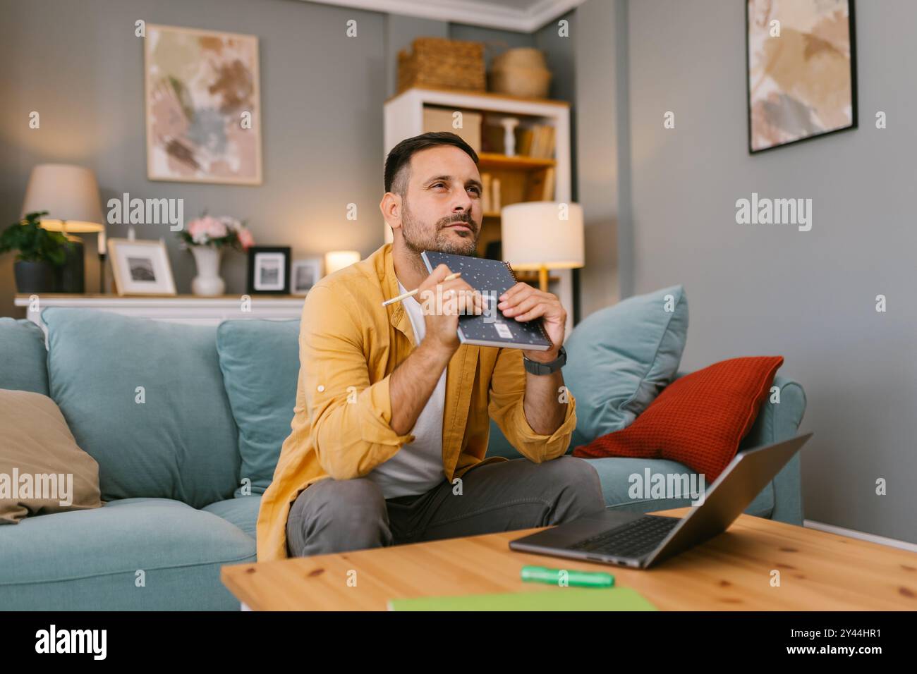 Man thinking while working from living room Stock Photo - Alamy