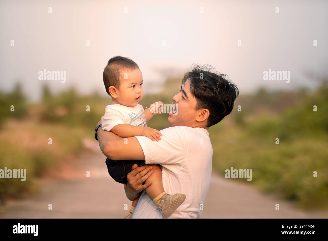 father smiled warmly at the baby boy while lifting the baby boy. father ...