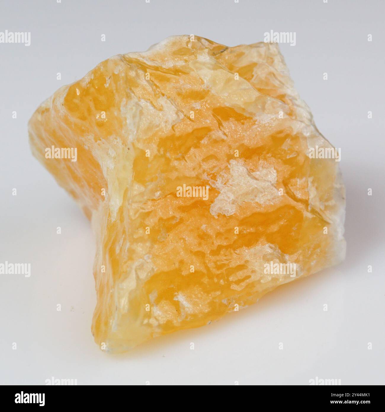 Radiant Textured Yellow Calcite Crystal on a Soft White Surface ...