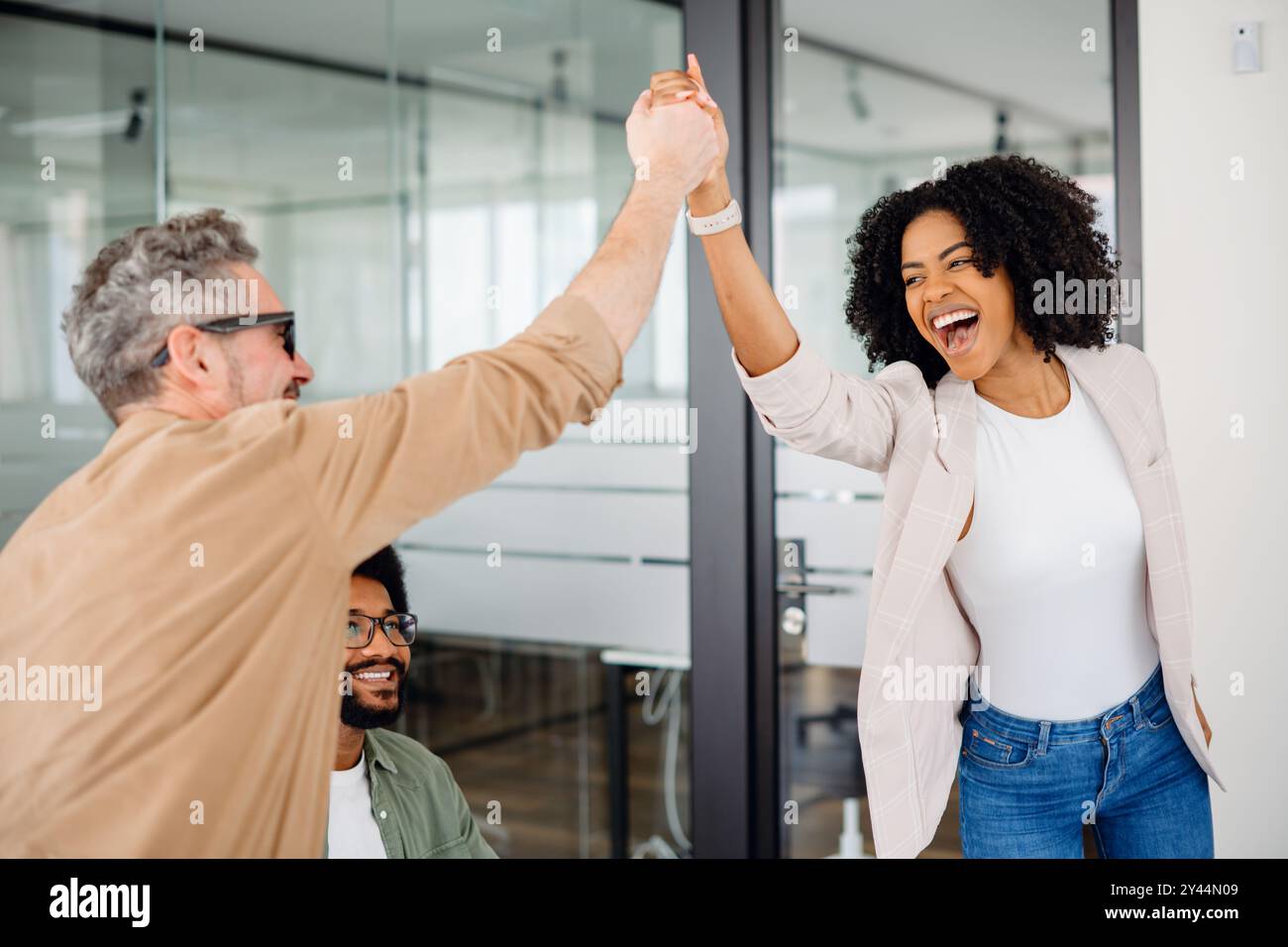 A high-five moment captures the joyful success within a team, as a ...